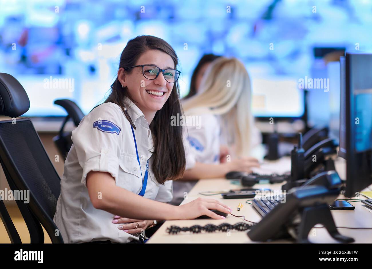 Female security operator working in a data system control room offices ...