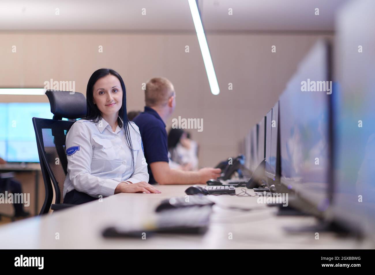 Female security operator working in a data system control room offices ...