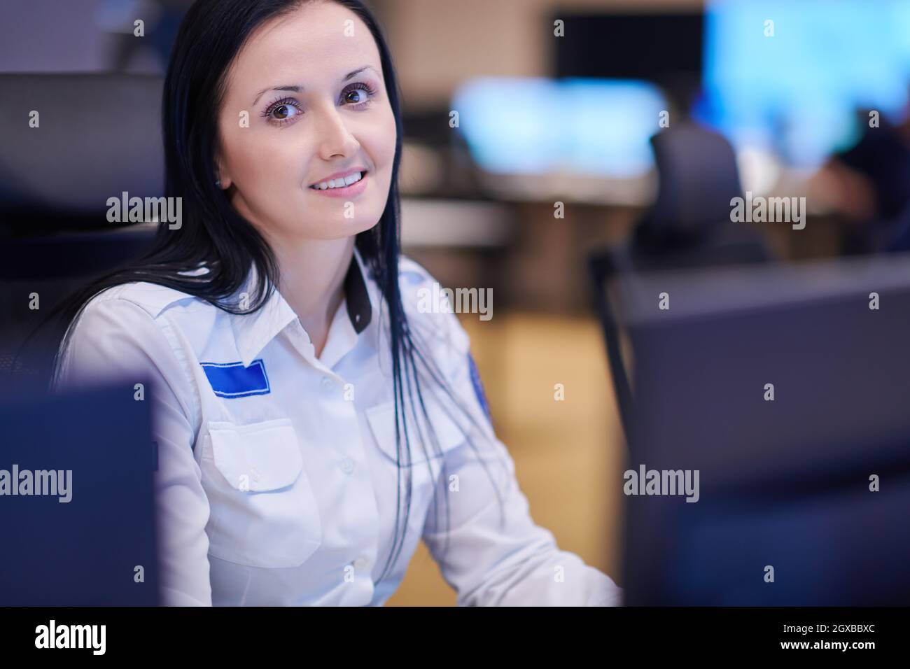 Female security operator working in a data system control room offices ...