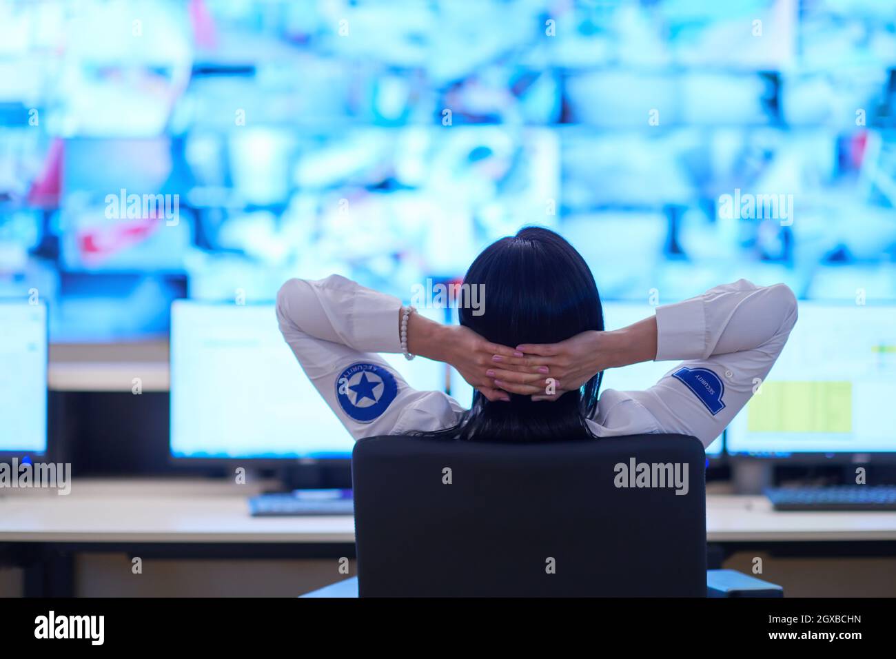 Female security operator working in a data system control room offices ...