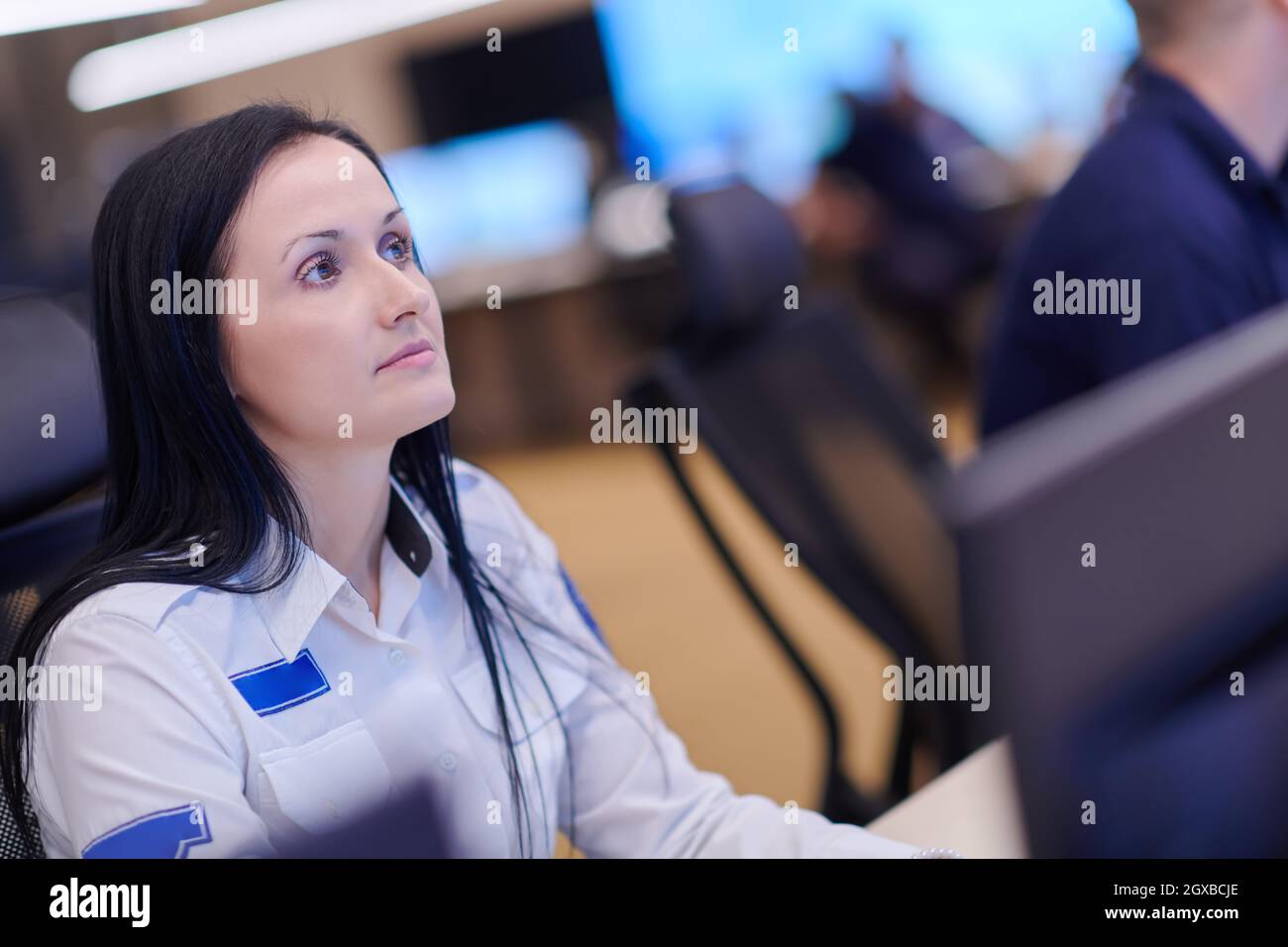 Female security operator working in a data system control room offices ...