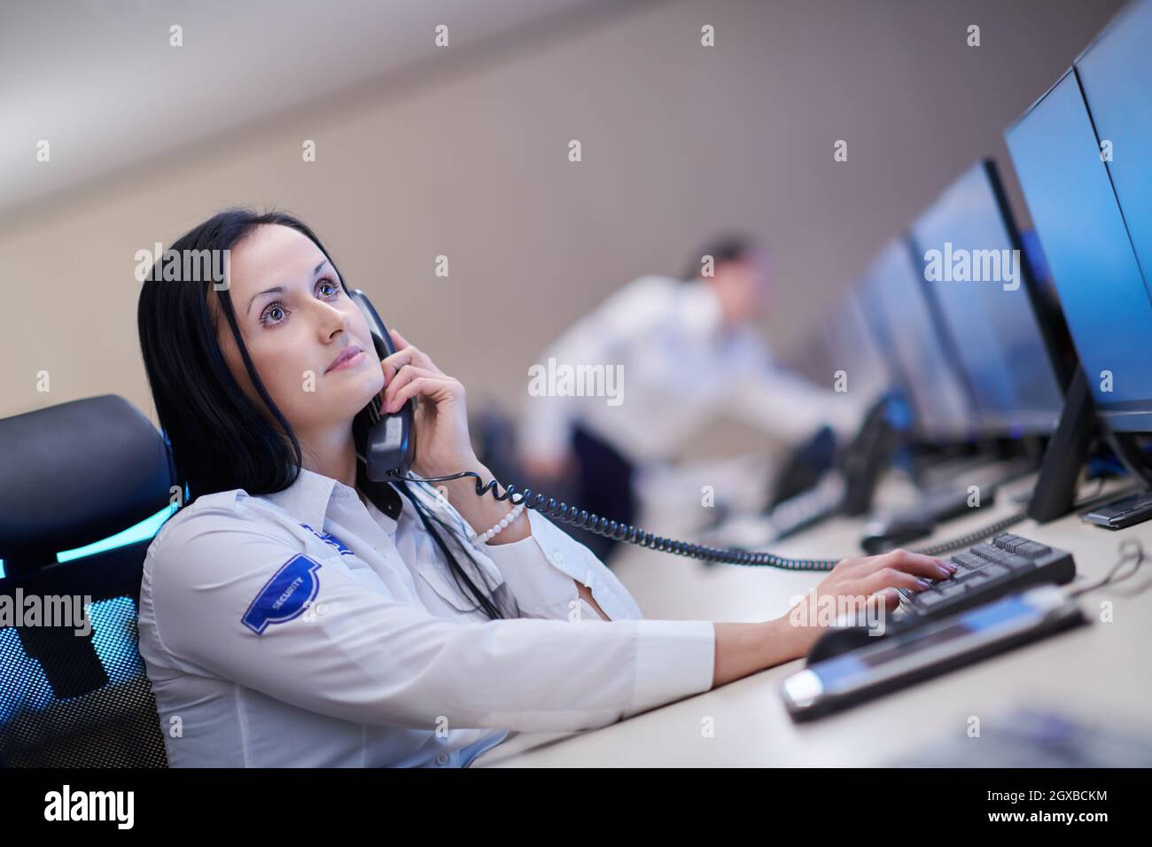 Female security guard operator talking on the phone while working at ...