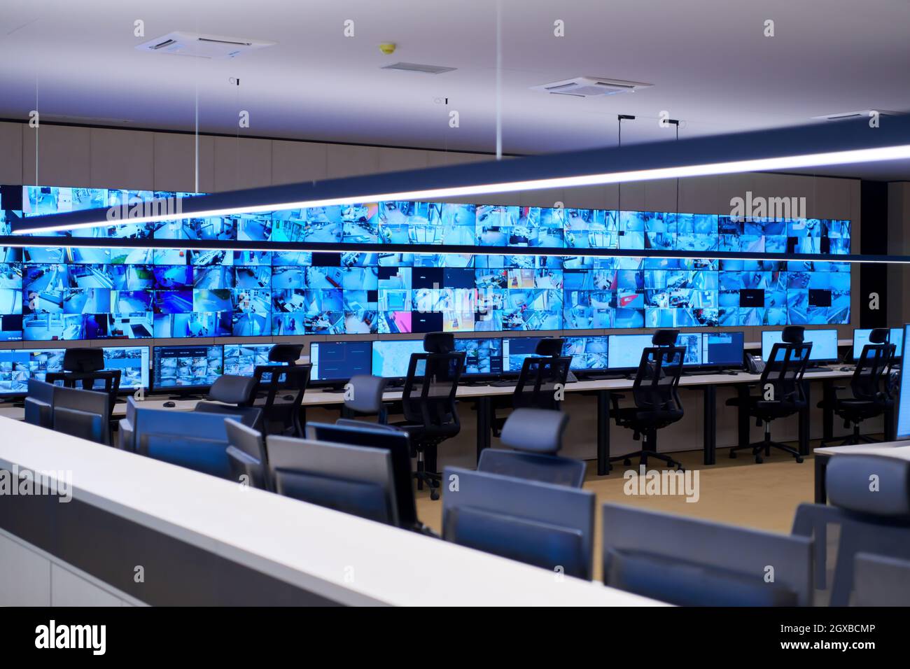 Empty interior of big modern security system control room, workstation with multiple displays ...