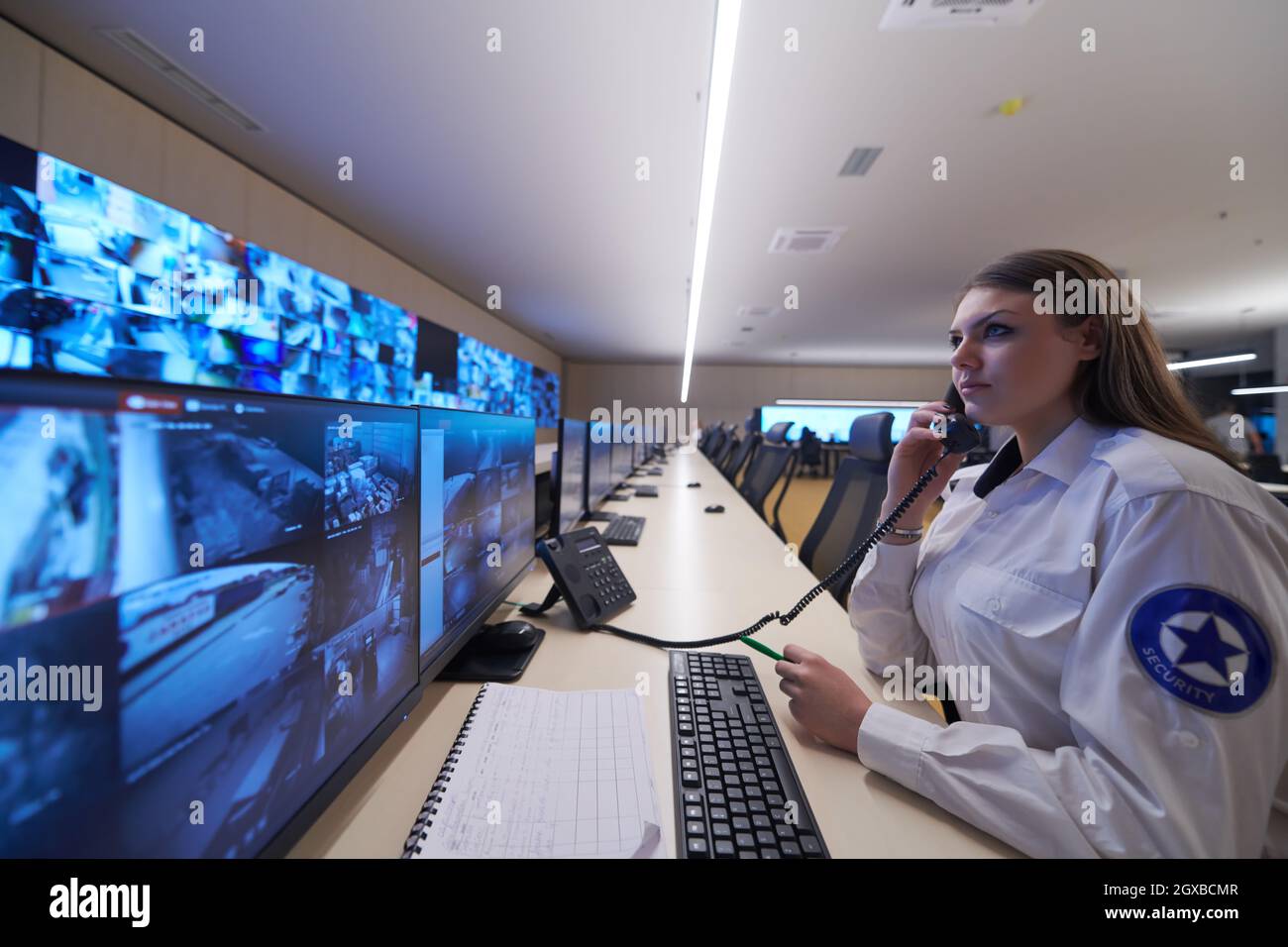 Female security guard operator talking on the phone while working at ...
