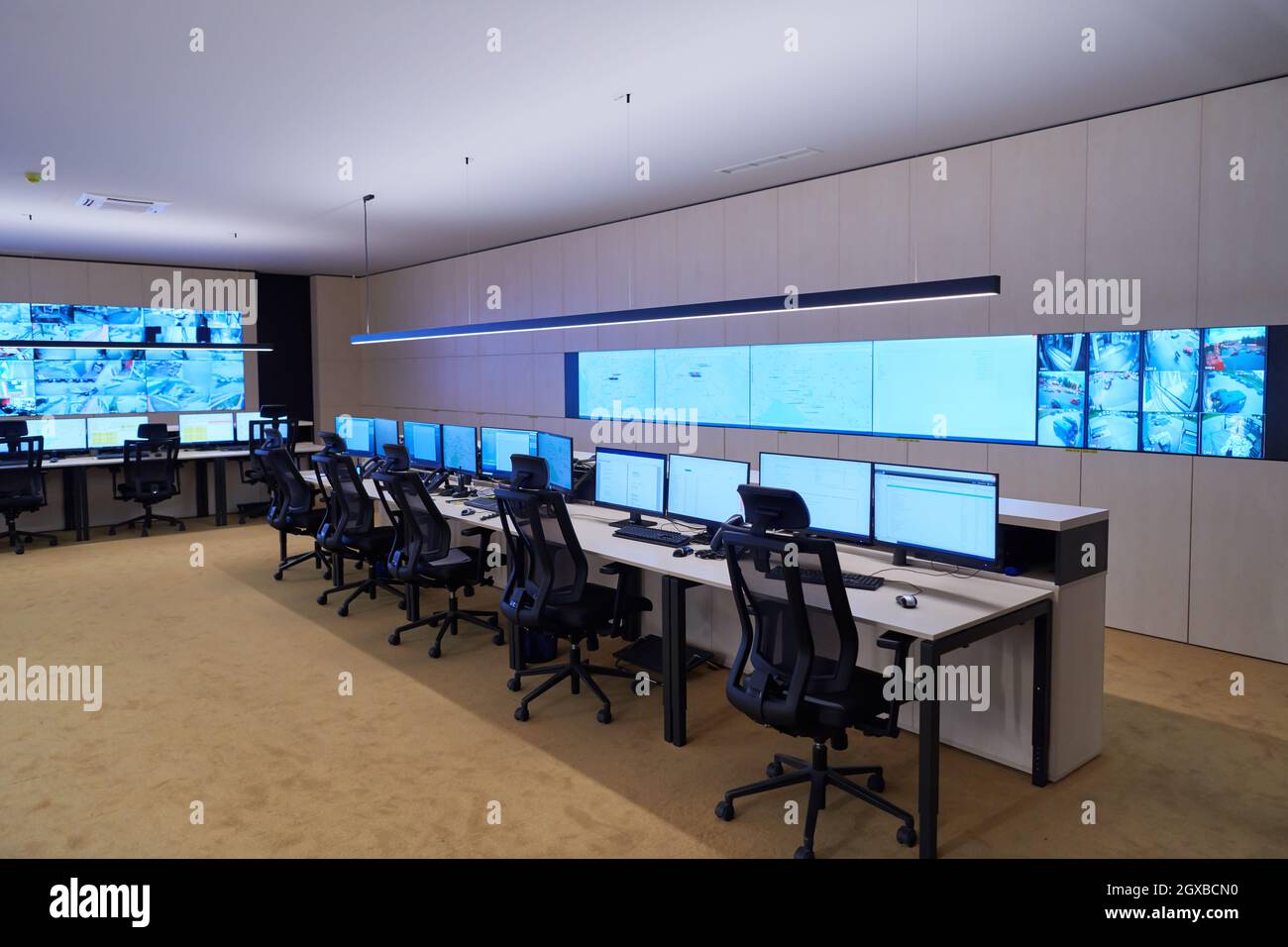 Empty interior of big modern security system control room, workstation with multiple displays ...
