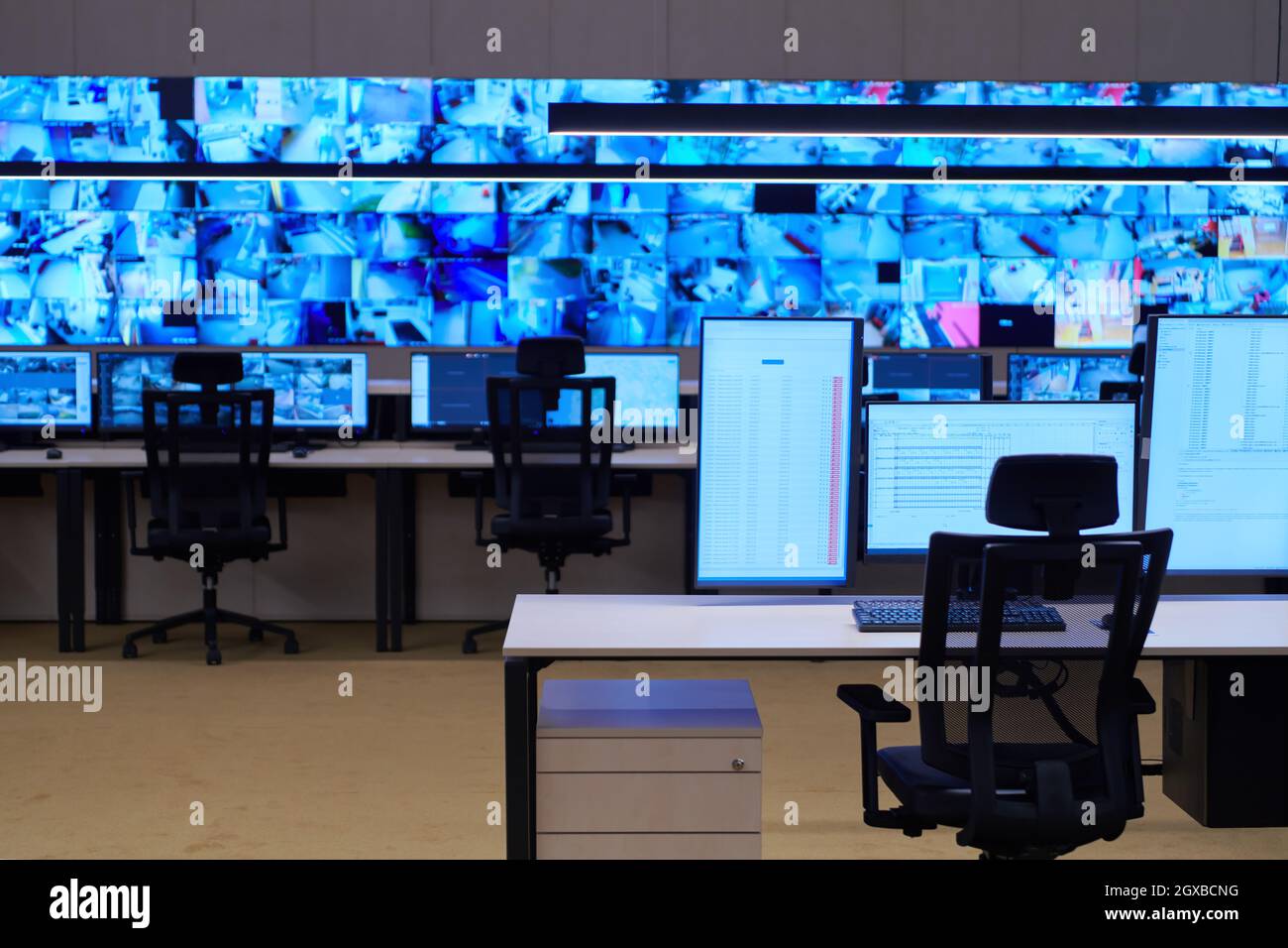 Empty interior of big modern security system control room, workstation ...