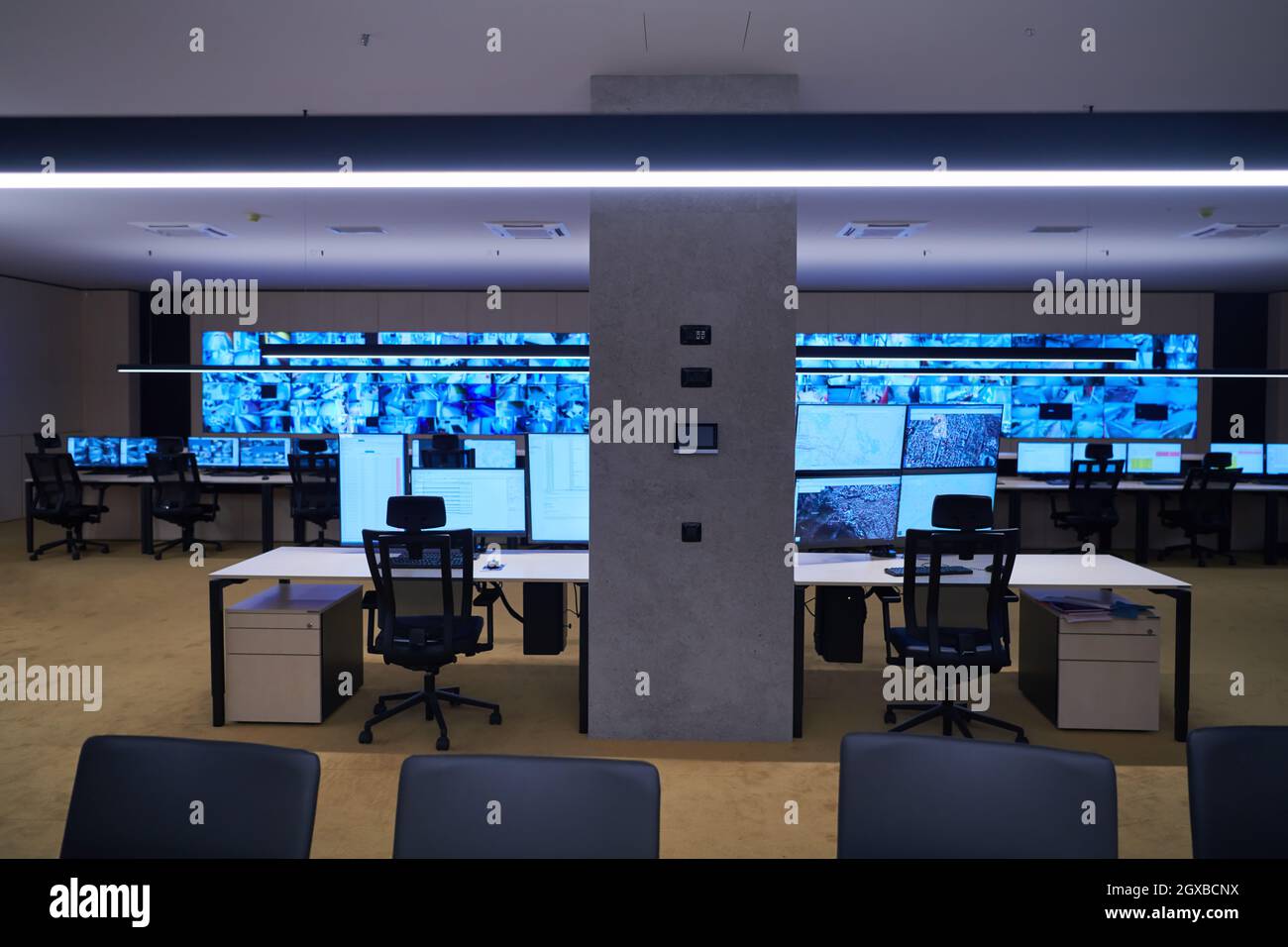Empty interior of big modern security system control room, workstation with multiple displays ...