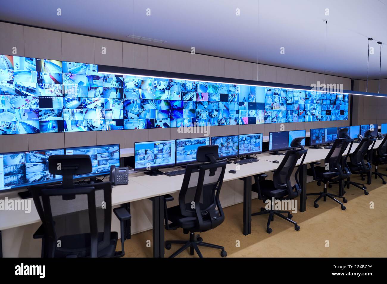 Empty interior of big modern security system control room, workstation with multiple displays ...