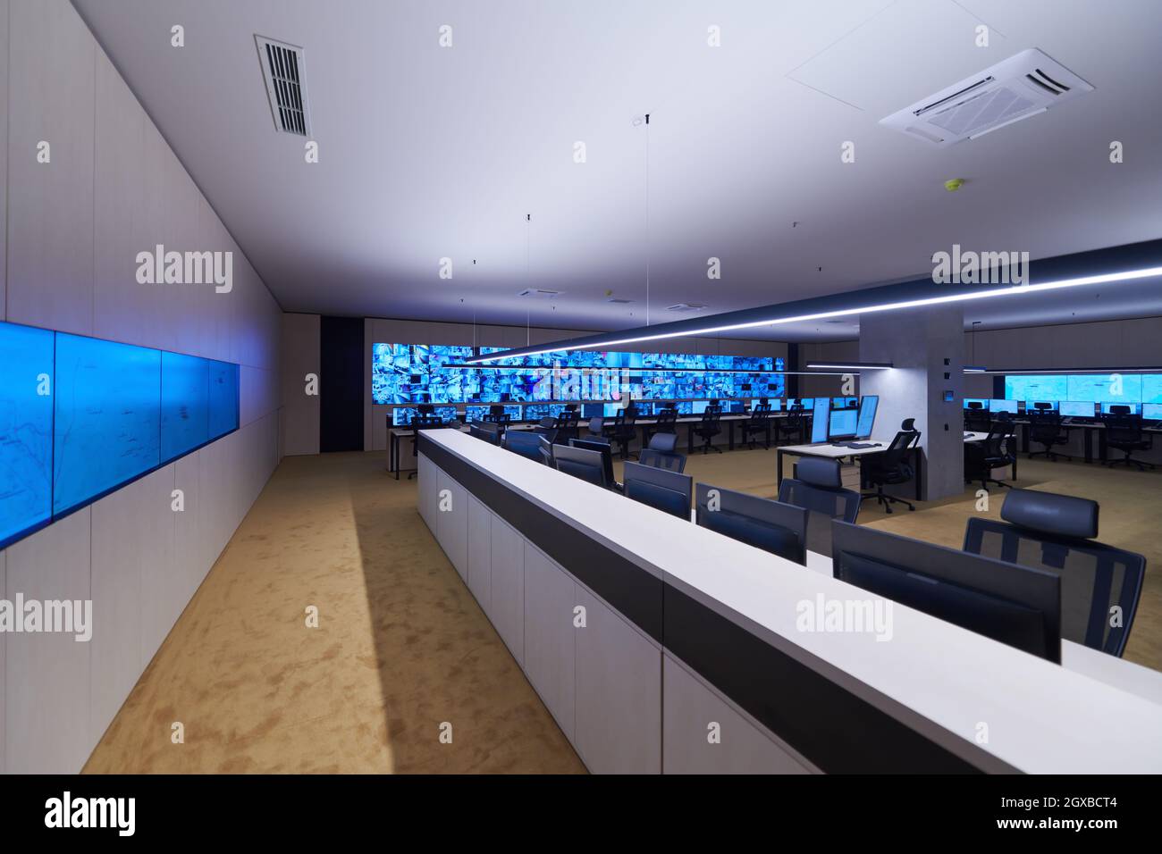 Empty interior of big modern security system control room, workstation with multiple displays ...