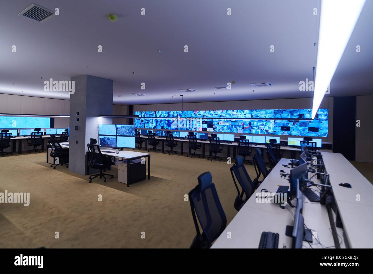 Empty interior of big modern security system control room, workstation with multiple displays ...