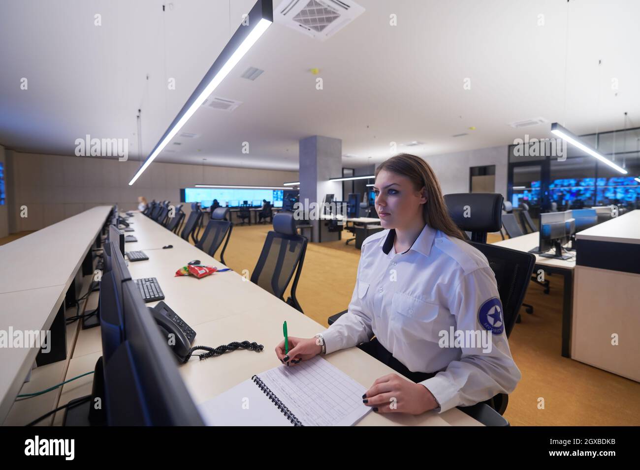 Female security operator working in a data system control room offices ...
