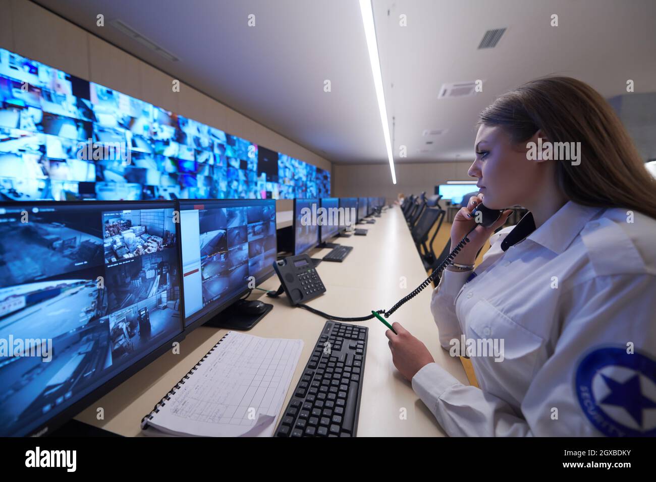Female security guard operator talking on the phone while working at ...