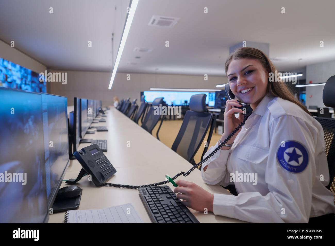 Female security guard operator talking on the phone while working at ...