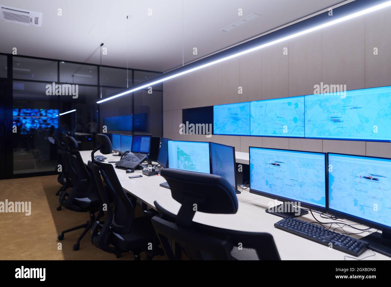 Empty interior of big modern security system control room, workstation with multiple displays ...