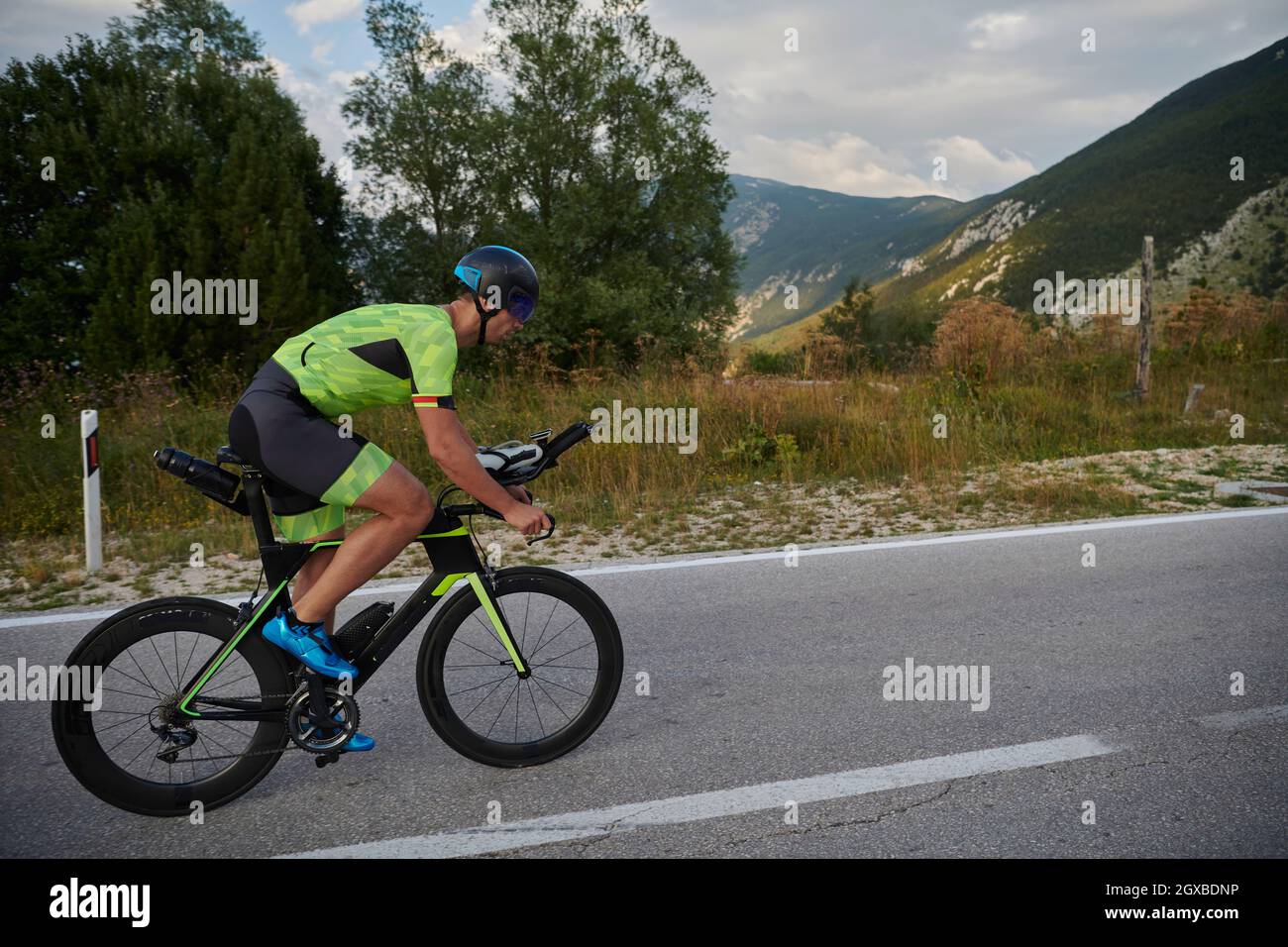 triathlon athlete riding professional racing bike at workout on curvy ...