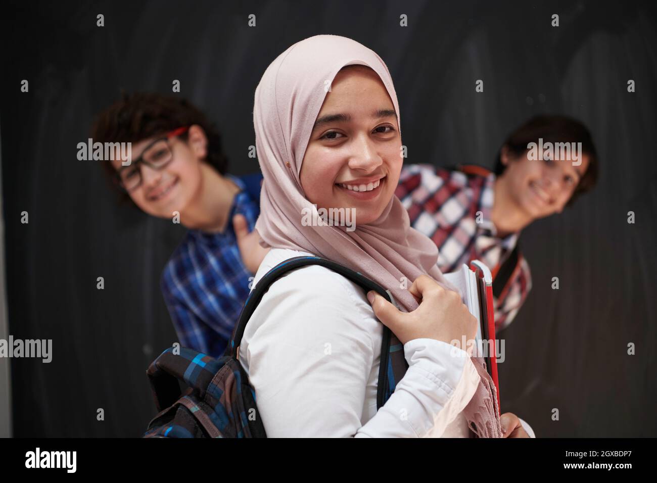 Arabic teenagers, students group portrait against black chalkboard ...