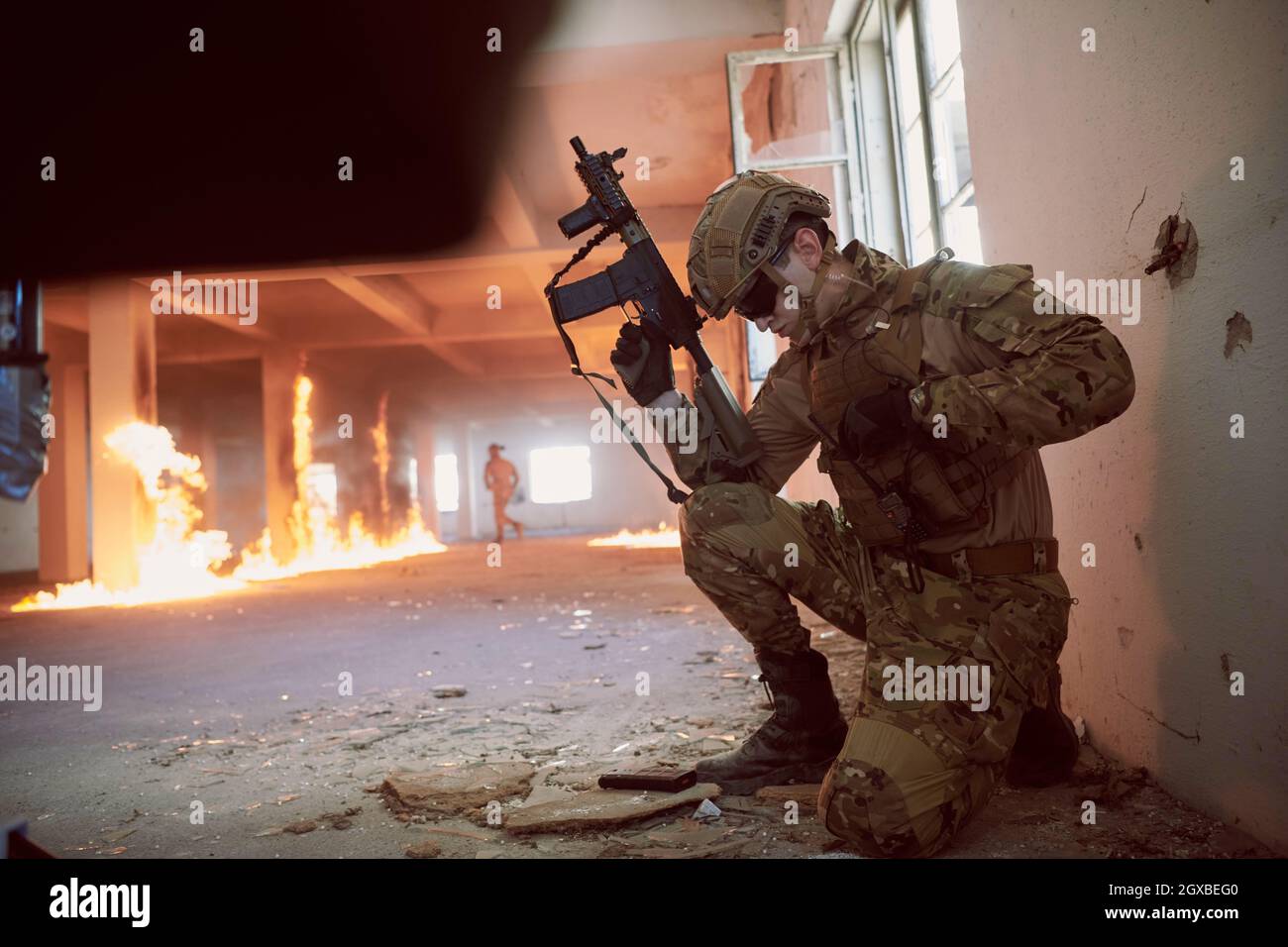 modern warfare soldier in action near window changing magazine and take ...