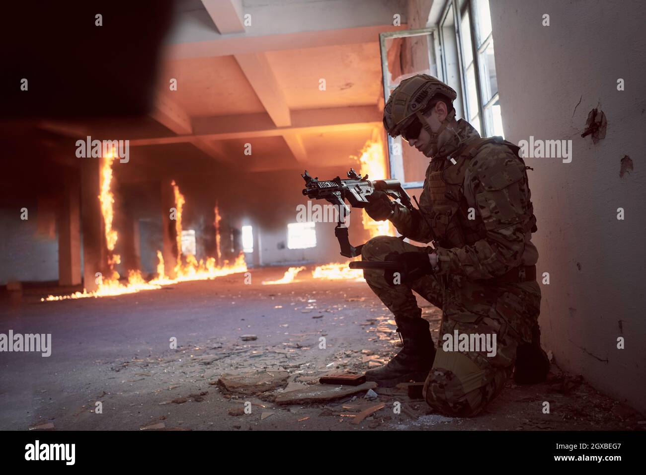 modern warfare soldier in action near window changing magazine and take ...
