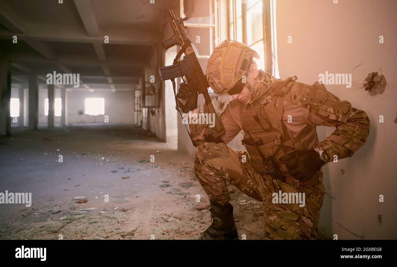 modern warfare soldier in action near window changing magazine and take ...