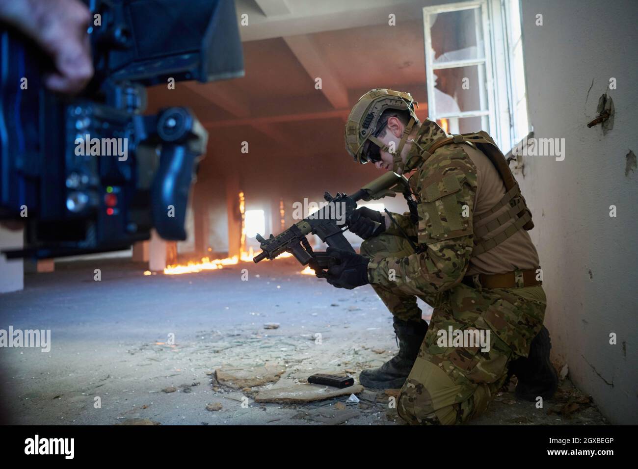 modern warfare soldier in action near window changing magazine and take ...