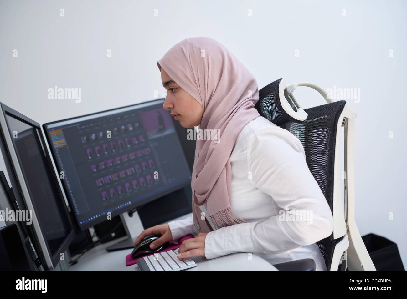 female Arabic creative professional working at home office on desktop ...
