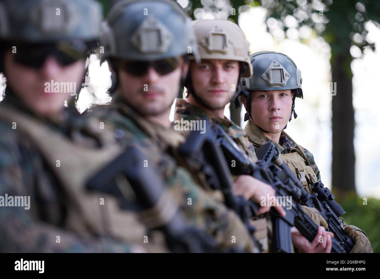 Soldier fighters standing together with guns. Group portrait of US army ...