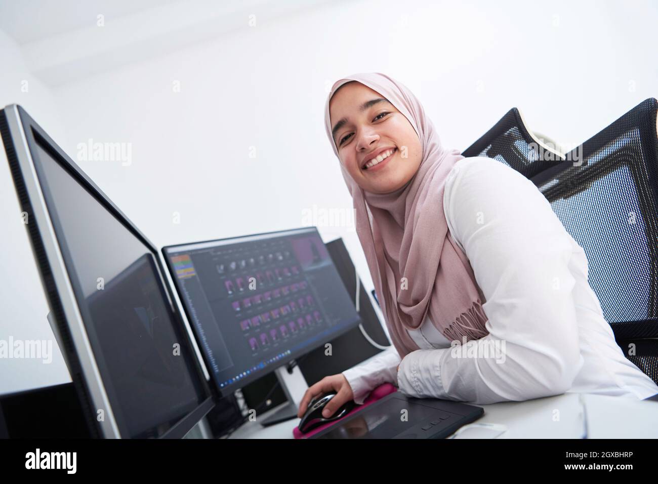 female Arabic creative professional working at home office on desktop ...