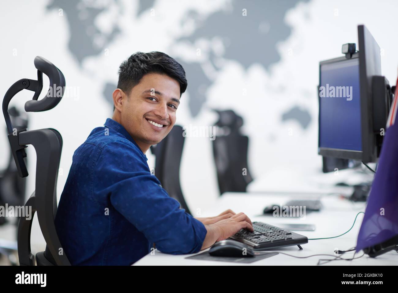 casual indian business man working on desktop computer in modern open ...