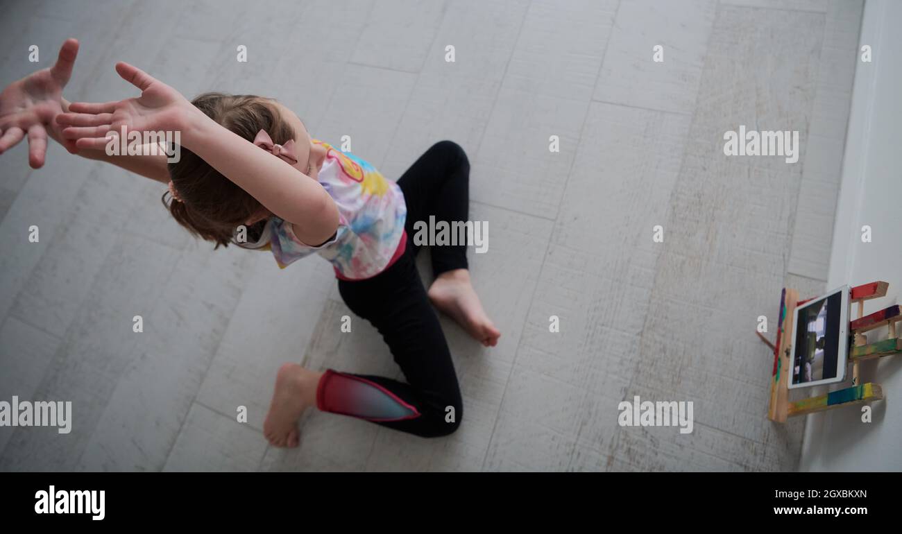 Little girl have online training over tablet and doing modern ballet ...