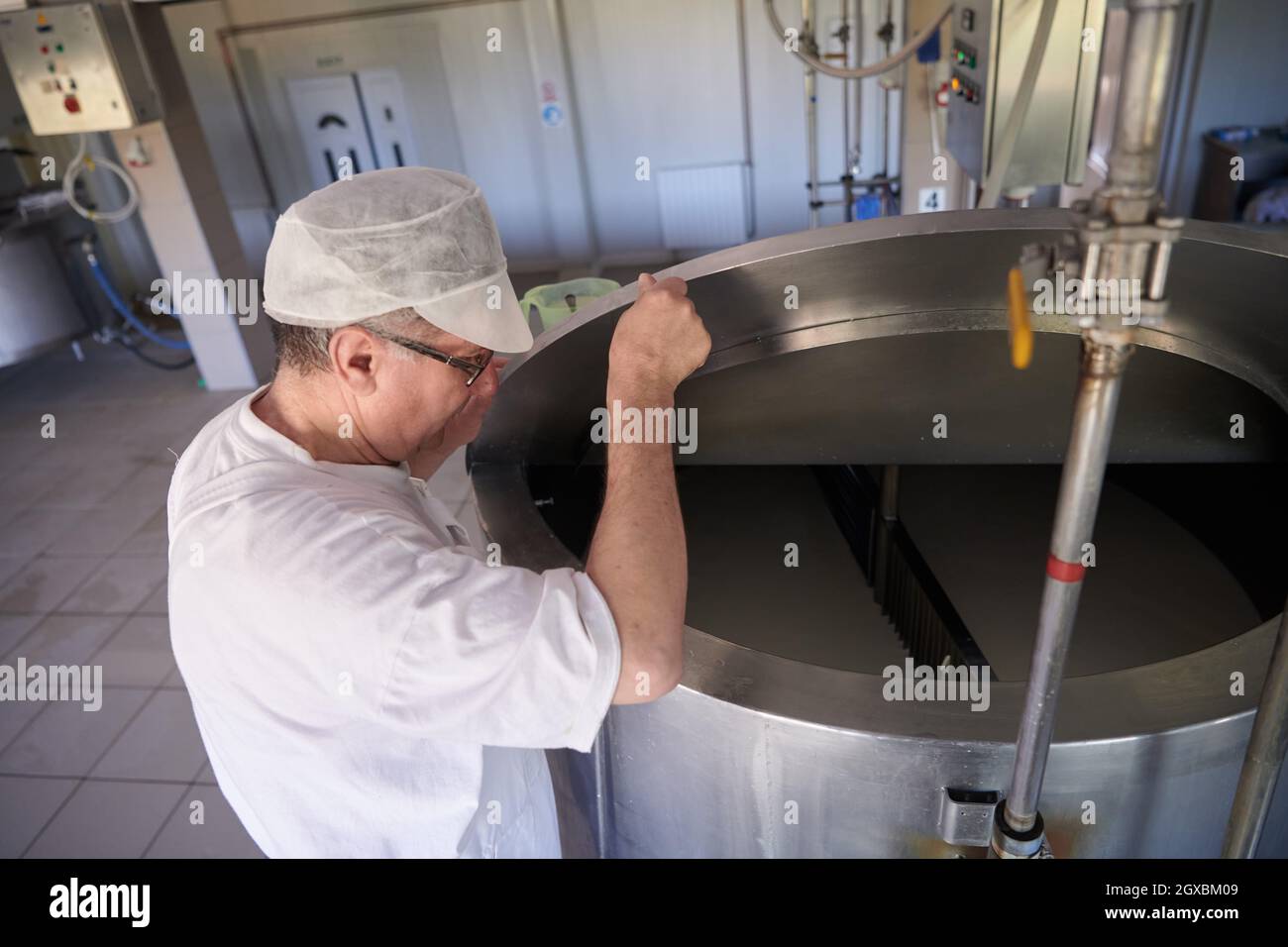 Cheese production male cheesemaker employee working in factory Stock ...