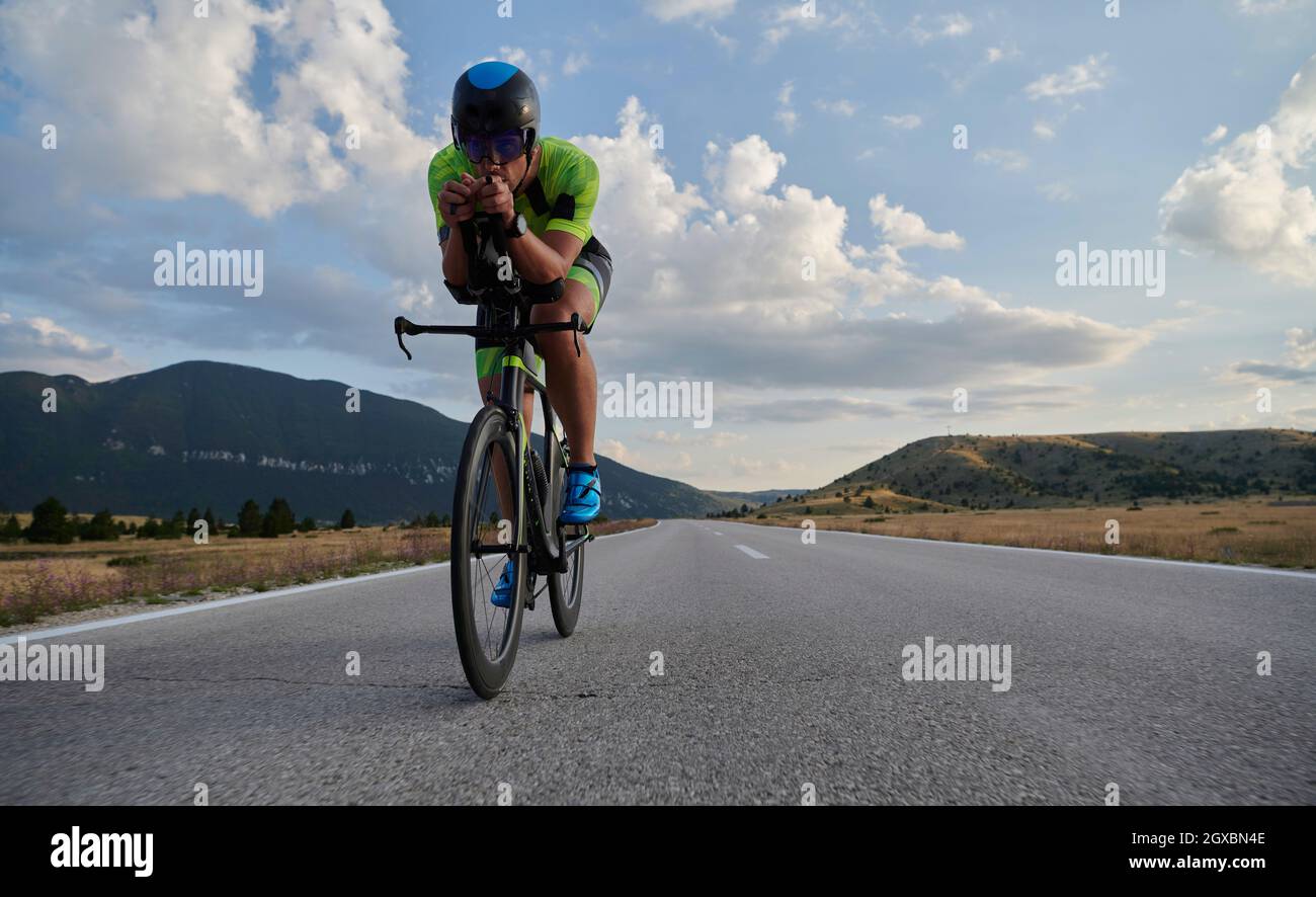 triathlon athlete riding professional racing bike at workout on curvy ...