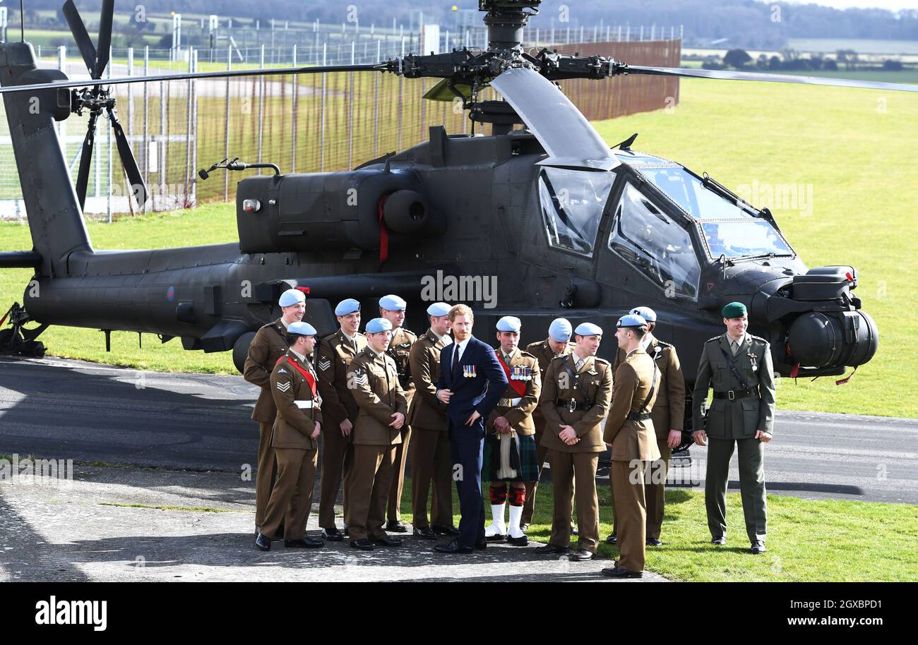 Prince Harry poses in front of an Apache helicopter after presenting ...
