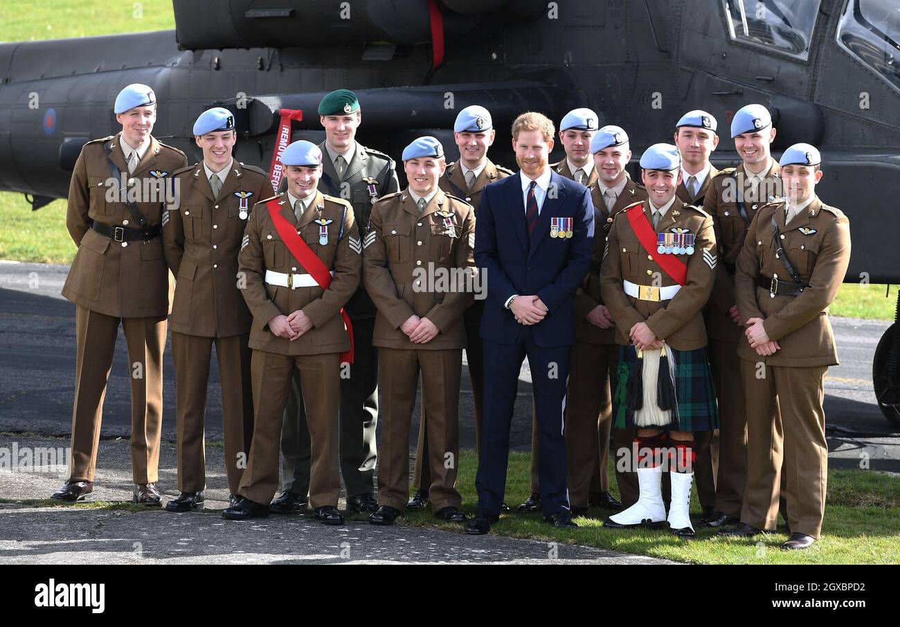 Prince Harry poses in front of an Apache helicopter after presenting ...