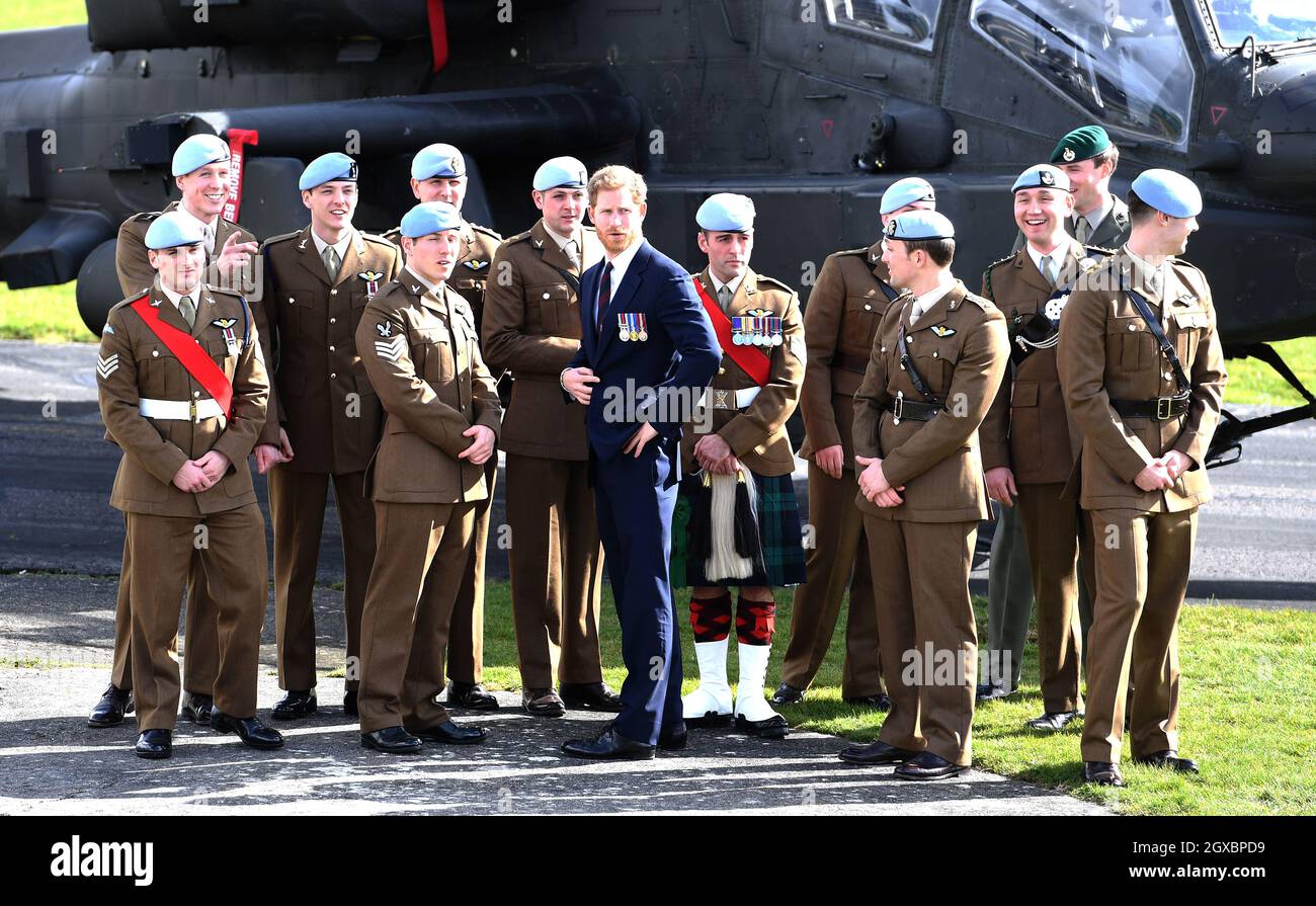 Prince Harry poses in front of an Apache helicopter after presenting ...