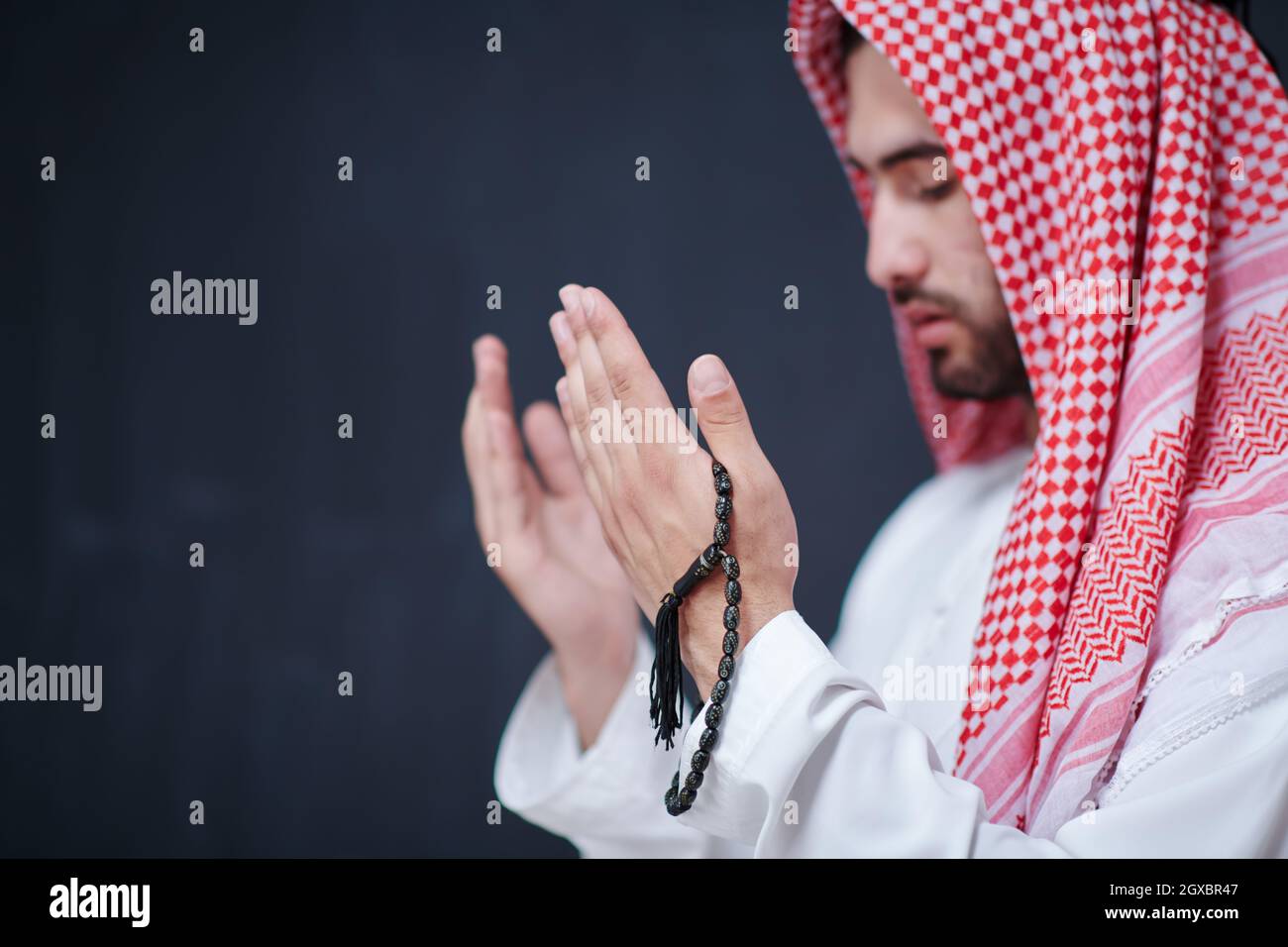 young arabian man in traditional clothes making traditional prayer to ...