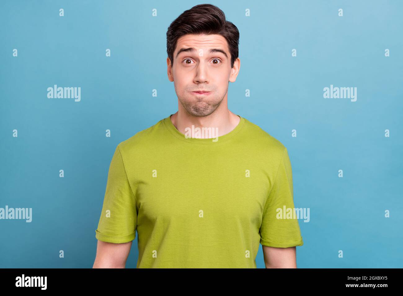 Photo of impressed handsome young guy dressed green t-shirt bloated ...