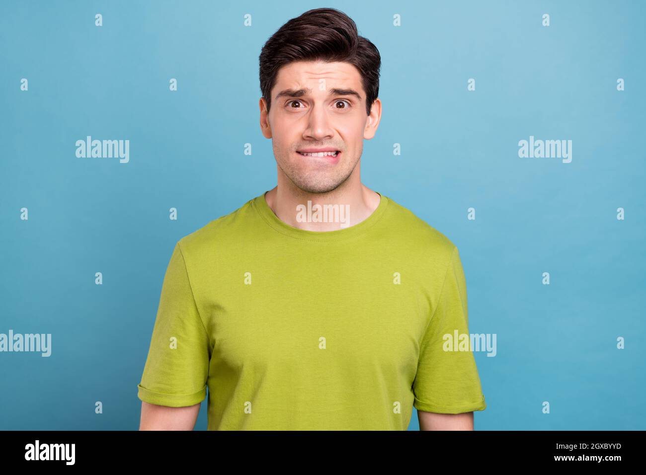 Portrait of attractive worried brown-haired guy biting lip isolated ...