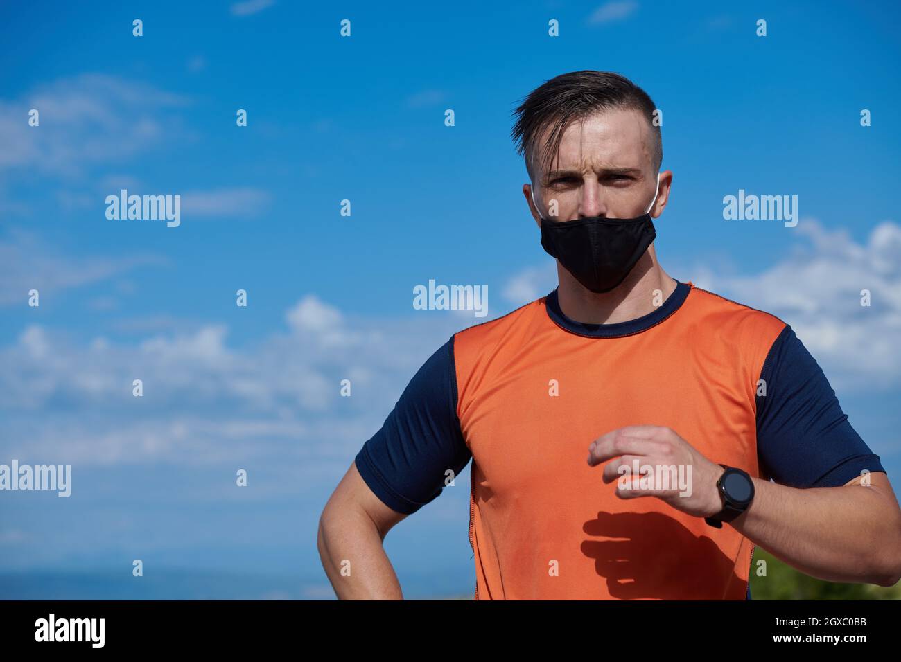 sporty man with protective face mask having a break and relaxing after ...