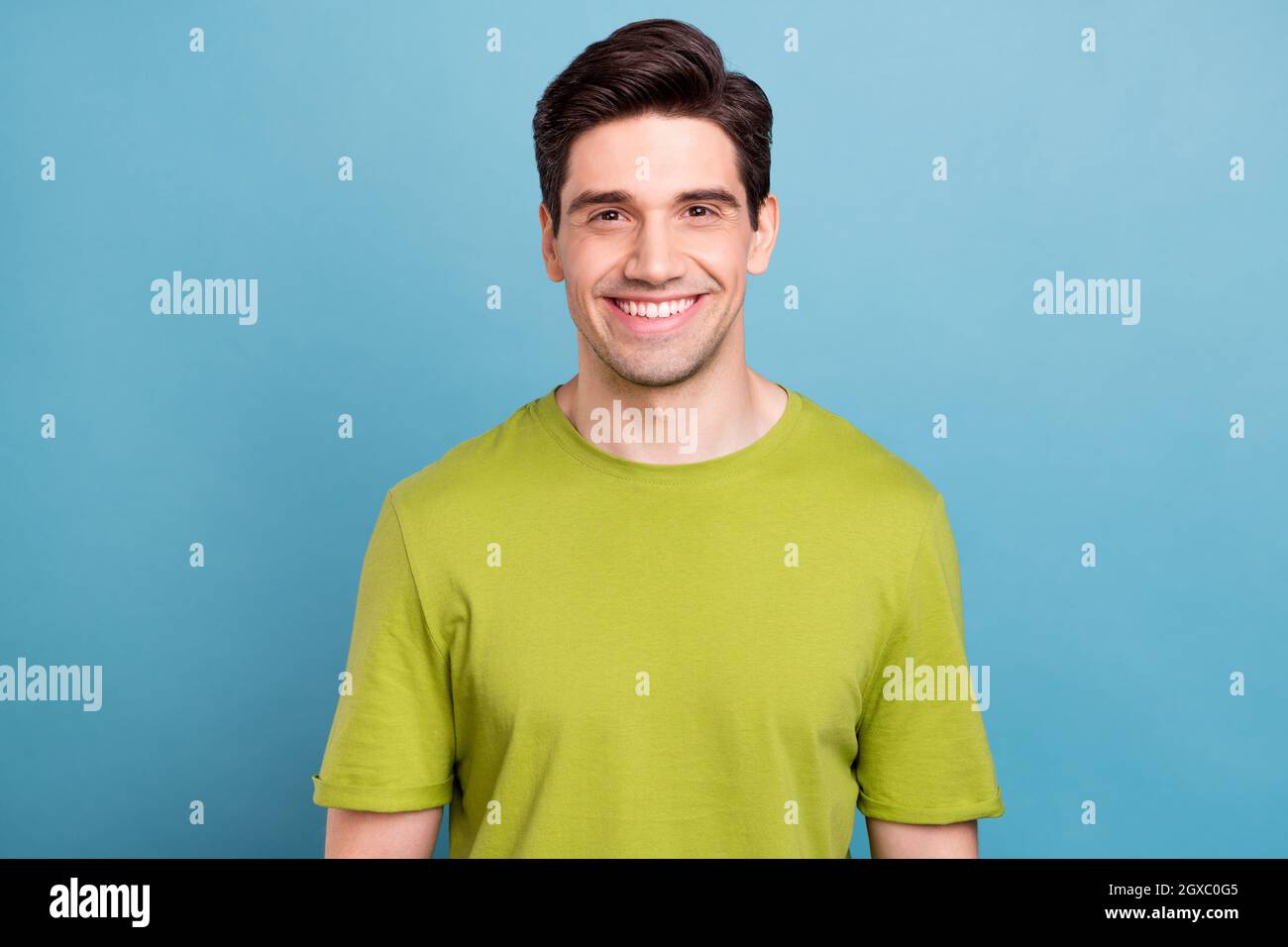 Photo of charming positive young guy dressed green t-shirt smiling ...
