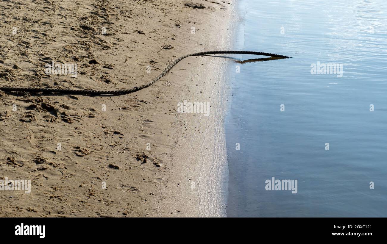 iron cable lies in the water, in summer Stock Photo - Alamy