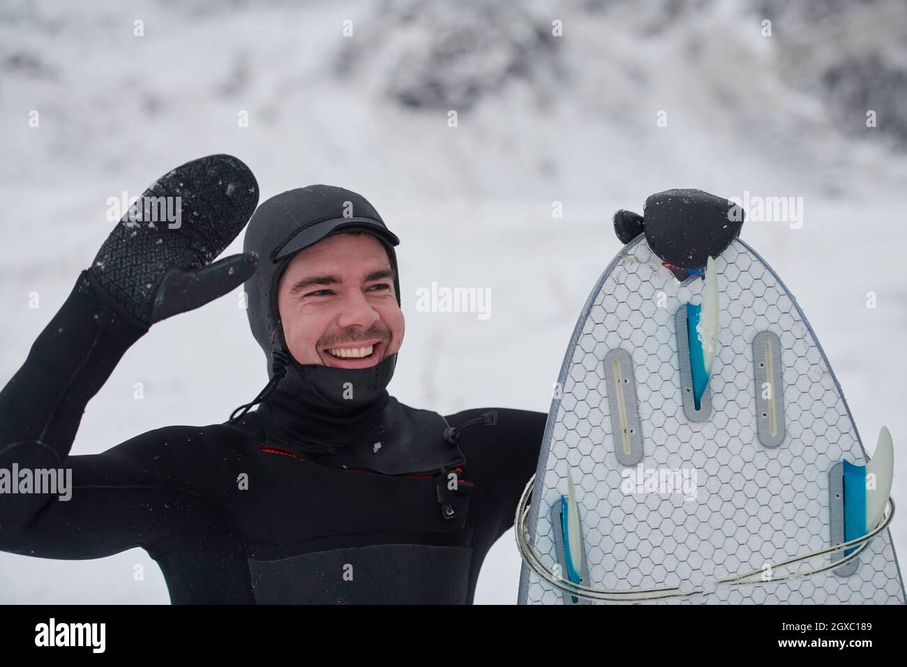Authentic local Arctic surfer portrait holding a board after surfing in ...