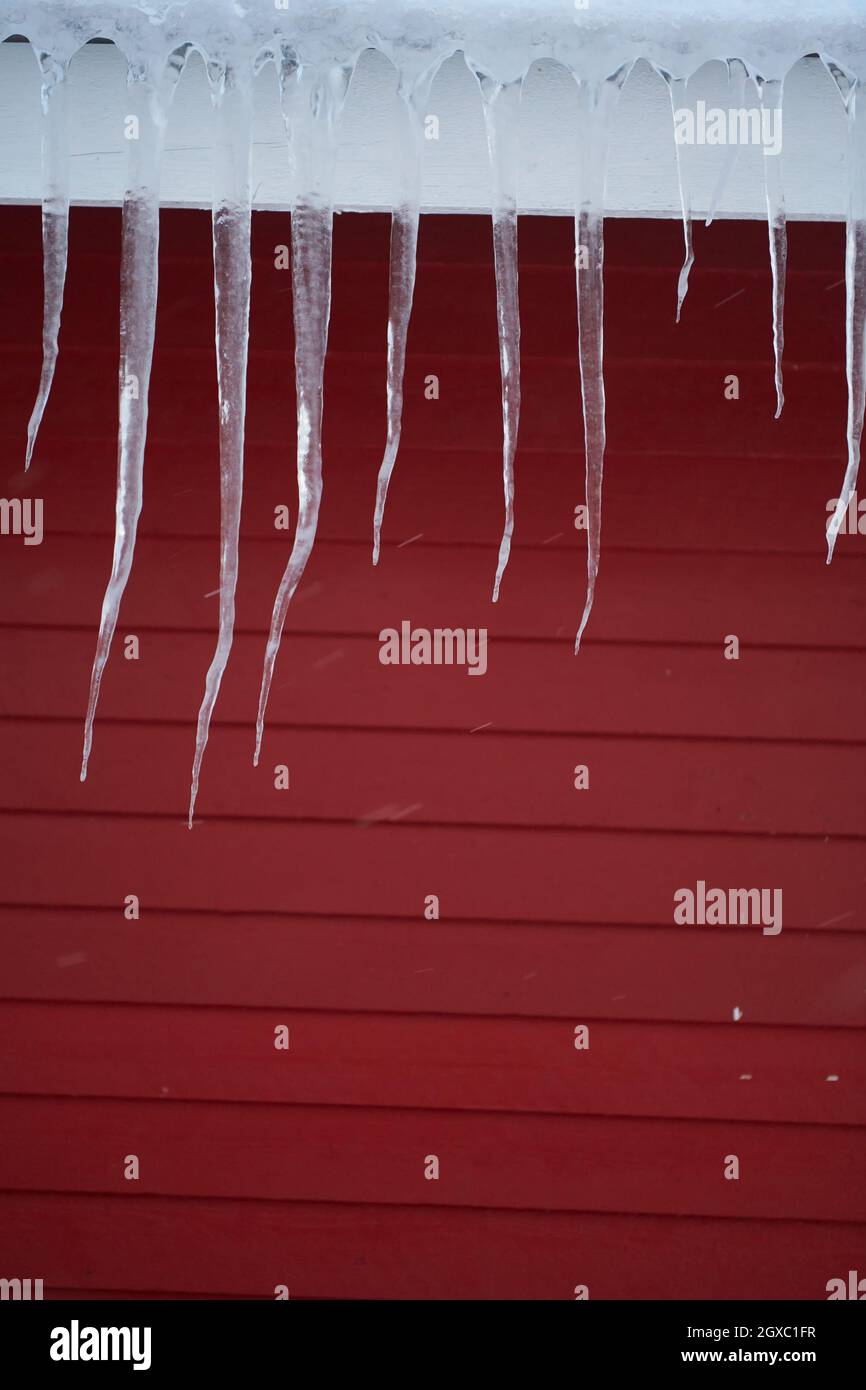 Icicles on the roof of a red house in Norway. melting icicles. natural ...