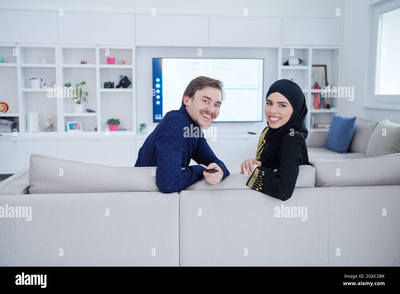 young muslim couple woman wearing islamic hijab clothes sitting on sofa ...