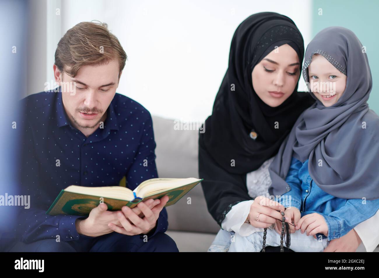 Traditional muslim family parents with children reading Quran and ...