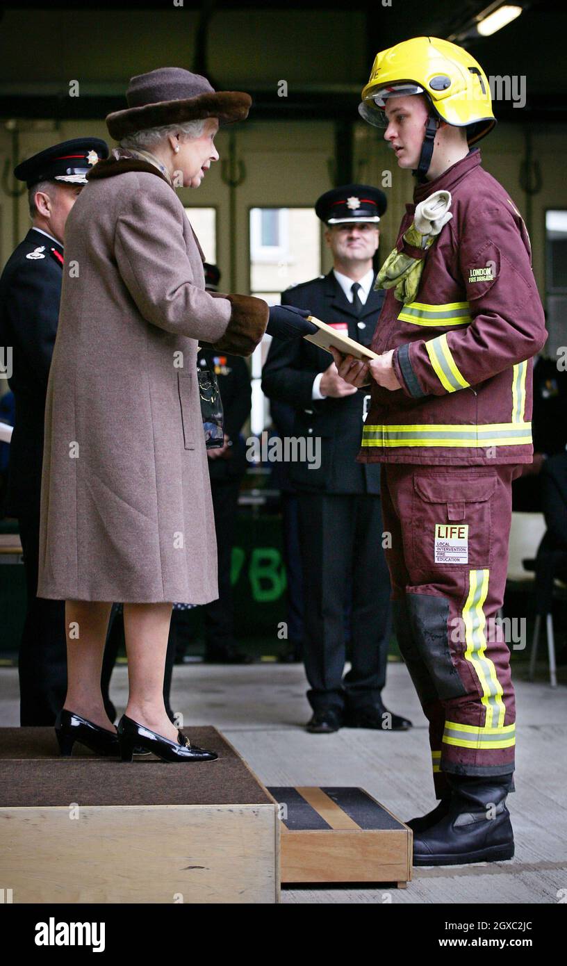 Queen Elizabeth II presents a certificate during a visit to Millwall ...