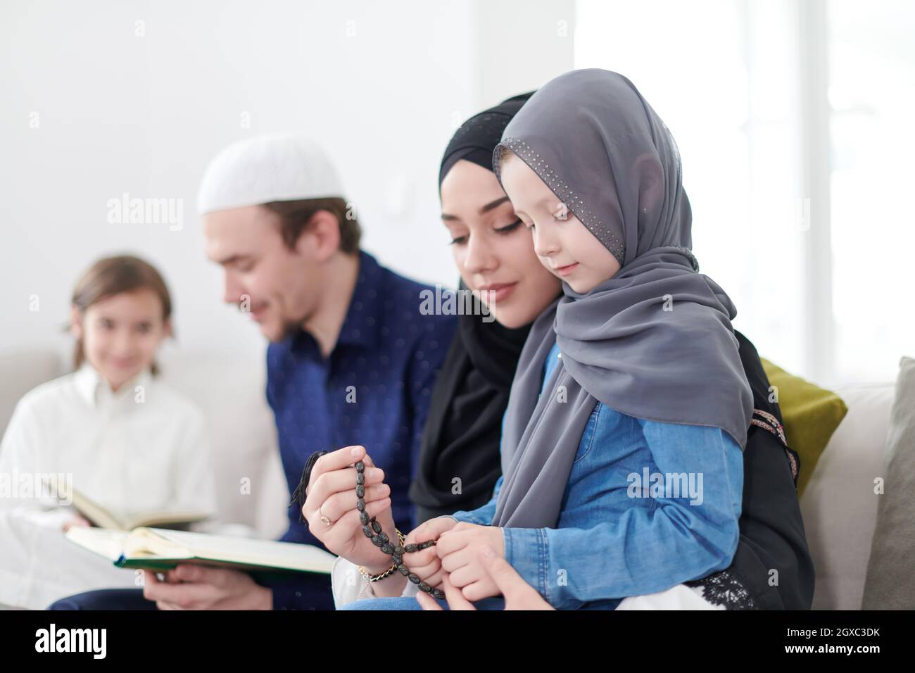 Traditional muslim family parents with children reading Quran and ...