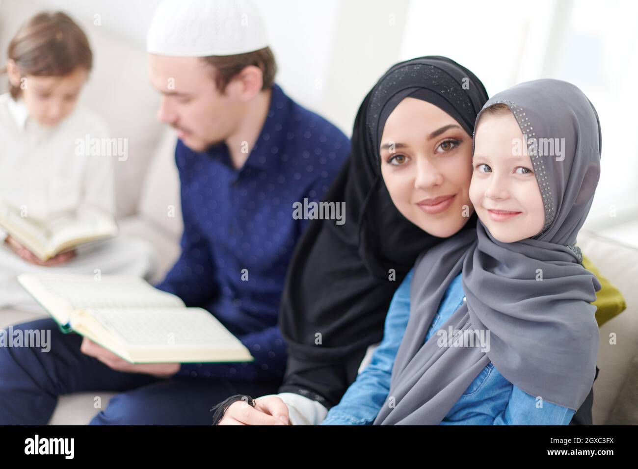 Traditional muslim family parents with children reading Quran and ...