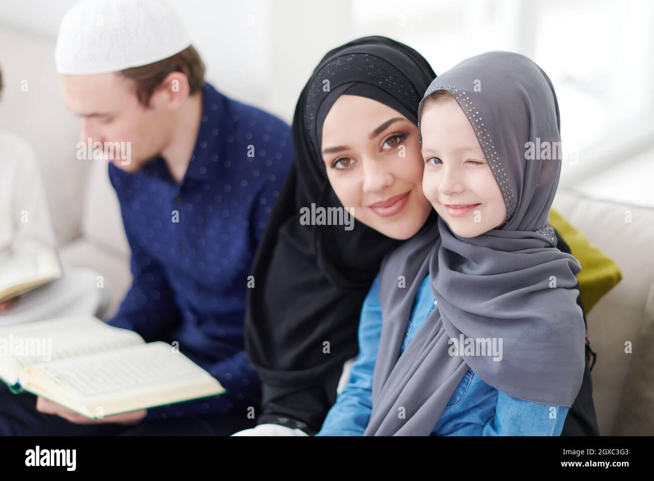 Traditional muslim family parents with children reading Quran and ...