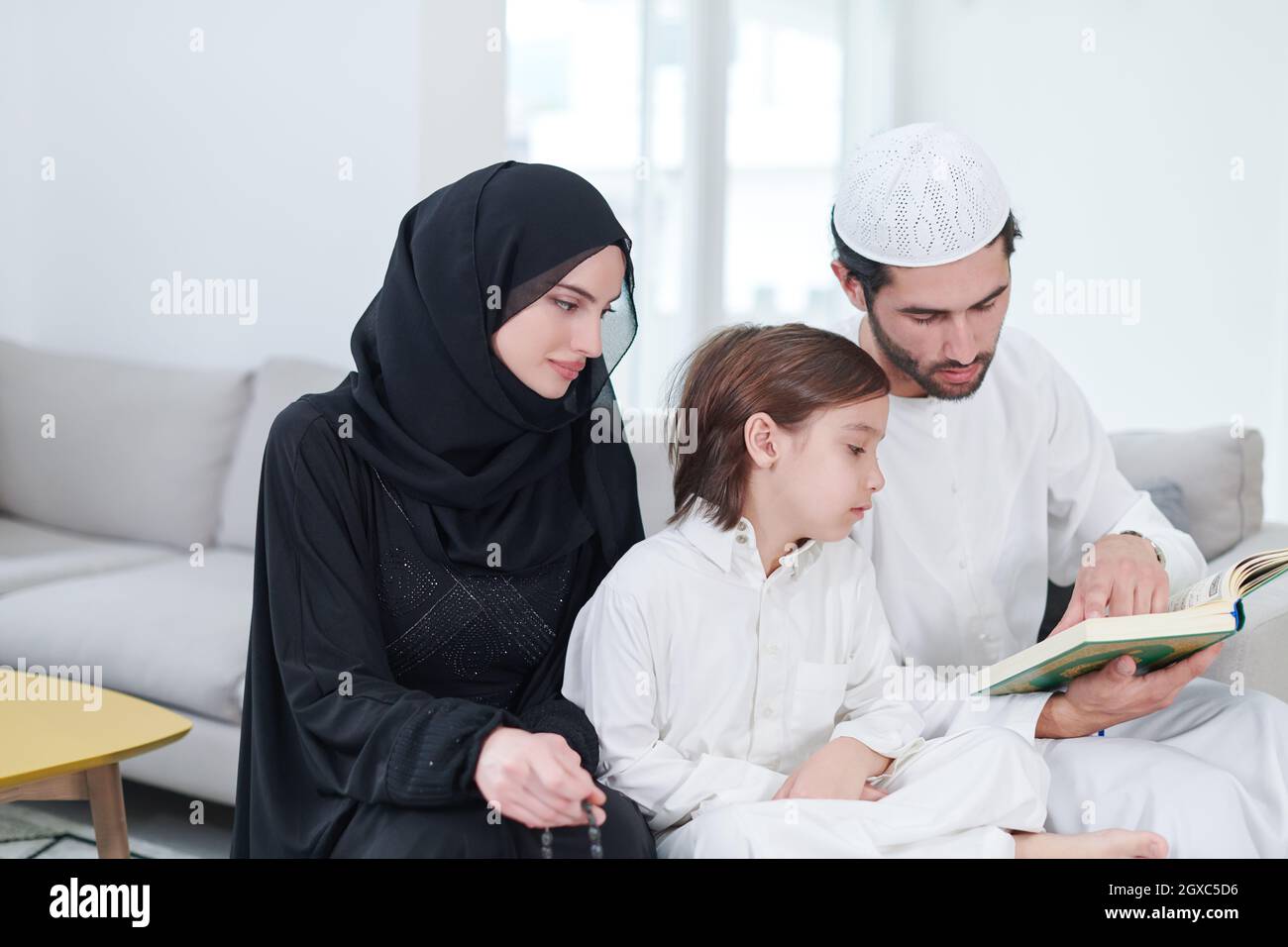 Traditional muslim family parents with children reading Quran and ...