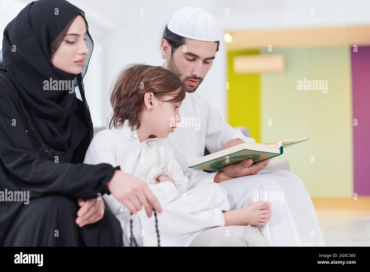 Traditional muslim family parents with children reading Quran and ...